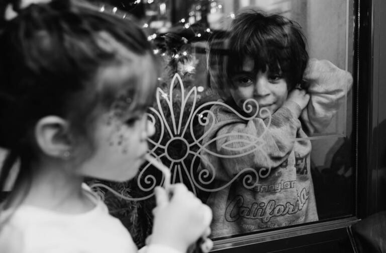Mala Romkinja gleda kroz staklo restorana kako njena vršnjakinja slavi ...